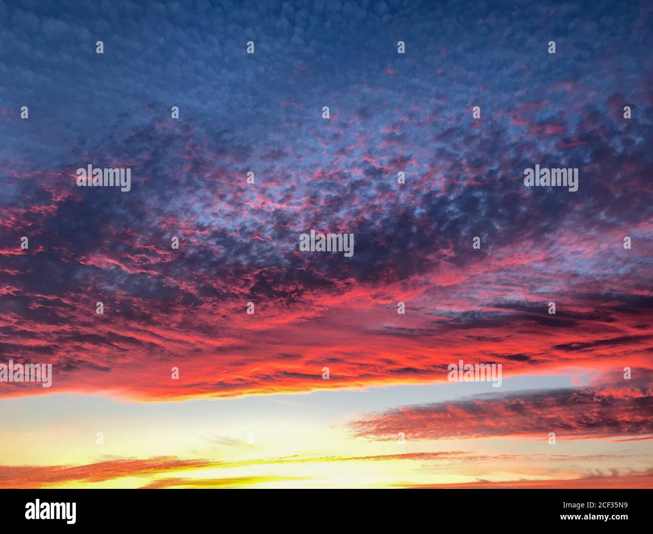 Spectacular magenta and orange sunset cloudscape in a twilight blue sky for a meteorological or ...
