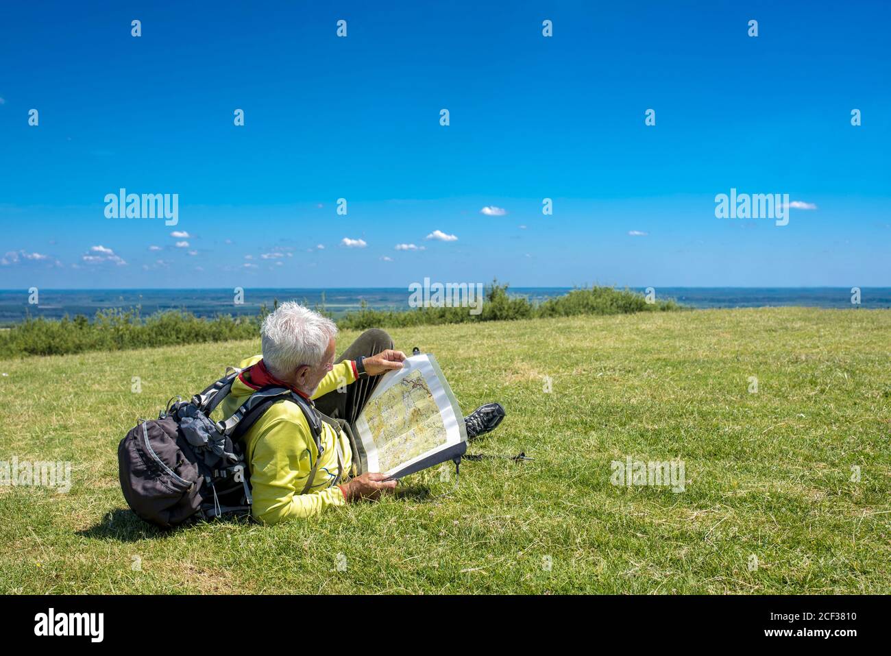 Old male hiker lying in a meadow and looking at a map Stock Photo - Alamy