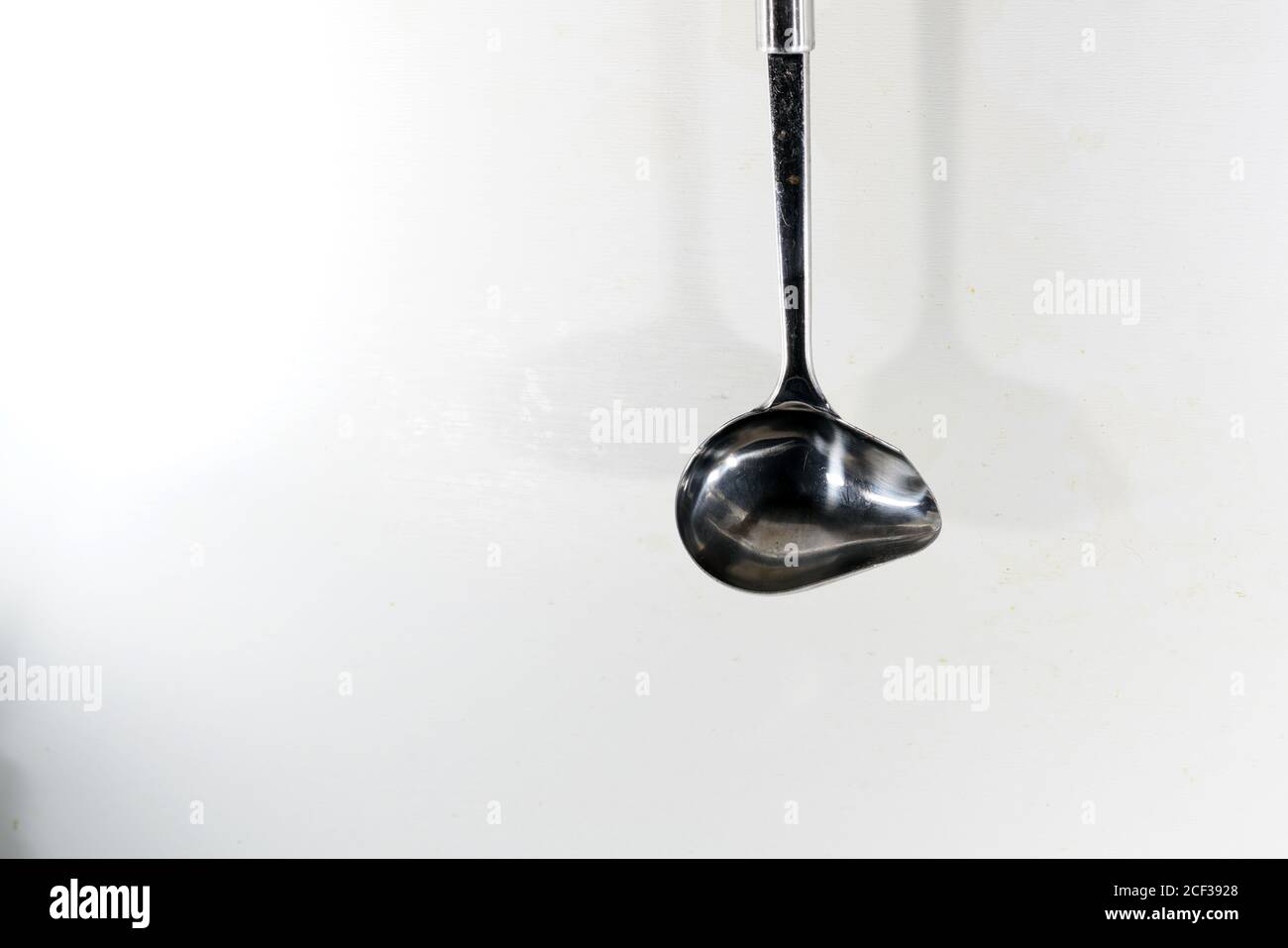 Kitchen spoon hanging from hangers with hooks Stock Photo - Alamy