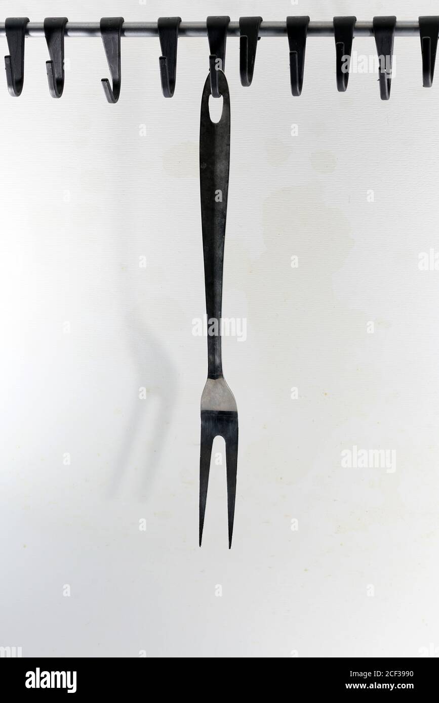 Fork hanging from hangers with hooks Stock Photo - Alamy