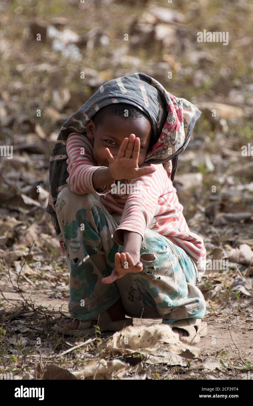 Shy east african girl with hand over face Stock Photo - Alamy