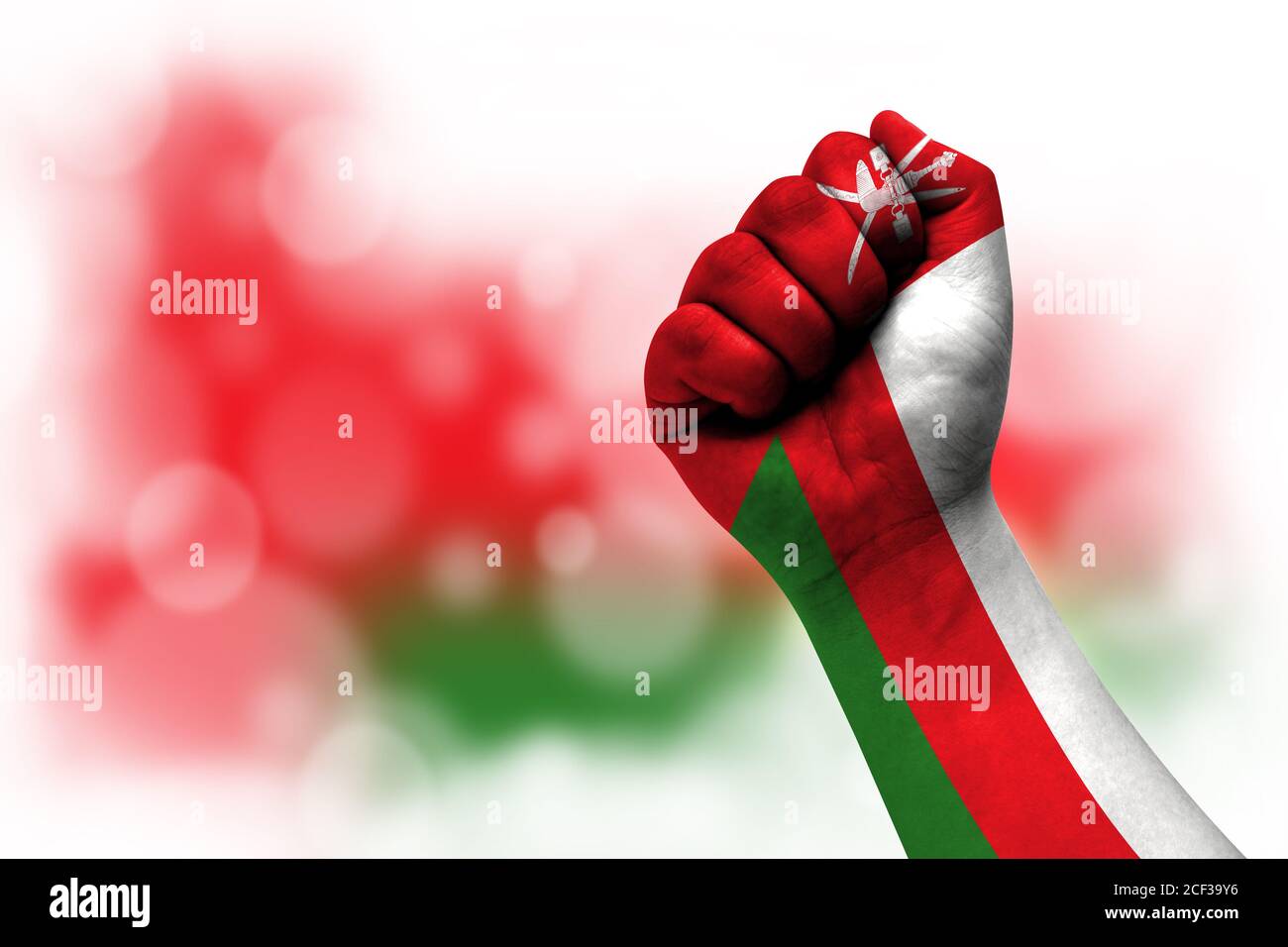 Flag of Oman painted on male fist, strength,power,concept of conflict ...