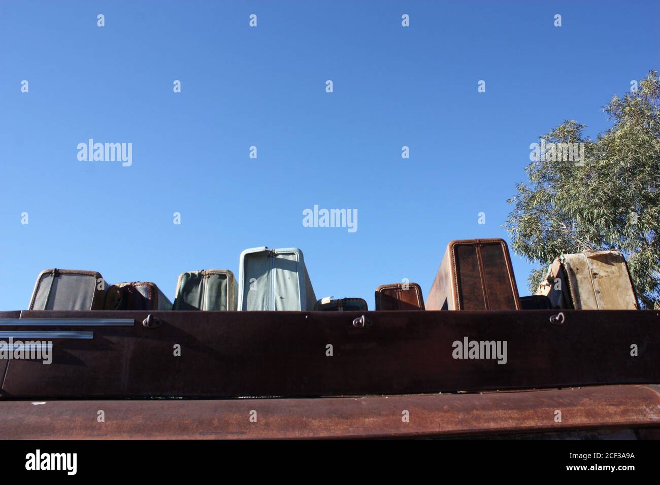 Antique luggage packed and ready-to-to on top of a rusty old classic ...