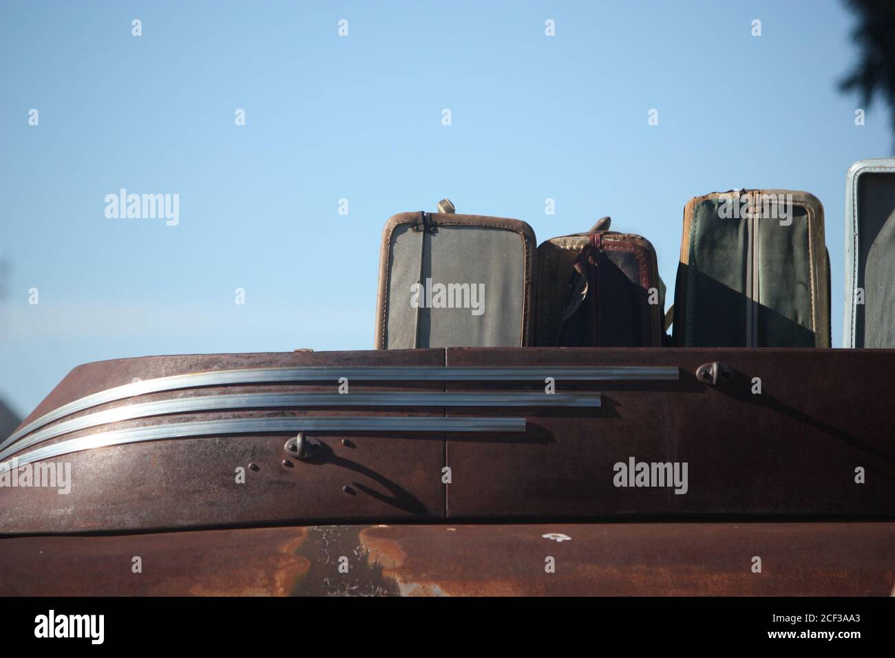 Antique luggage packed and ready-to-to on top of a rusty old classic ...