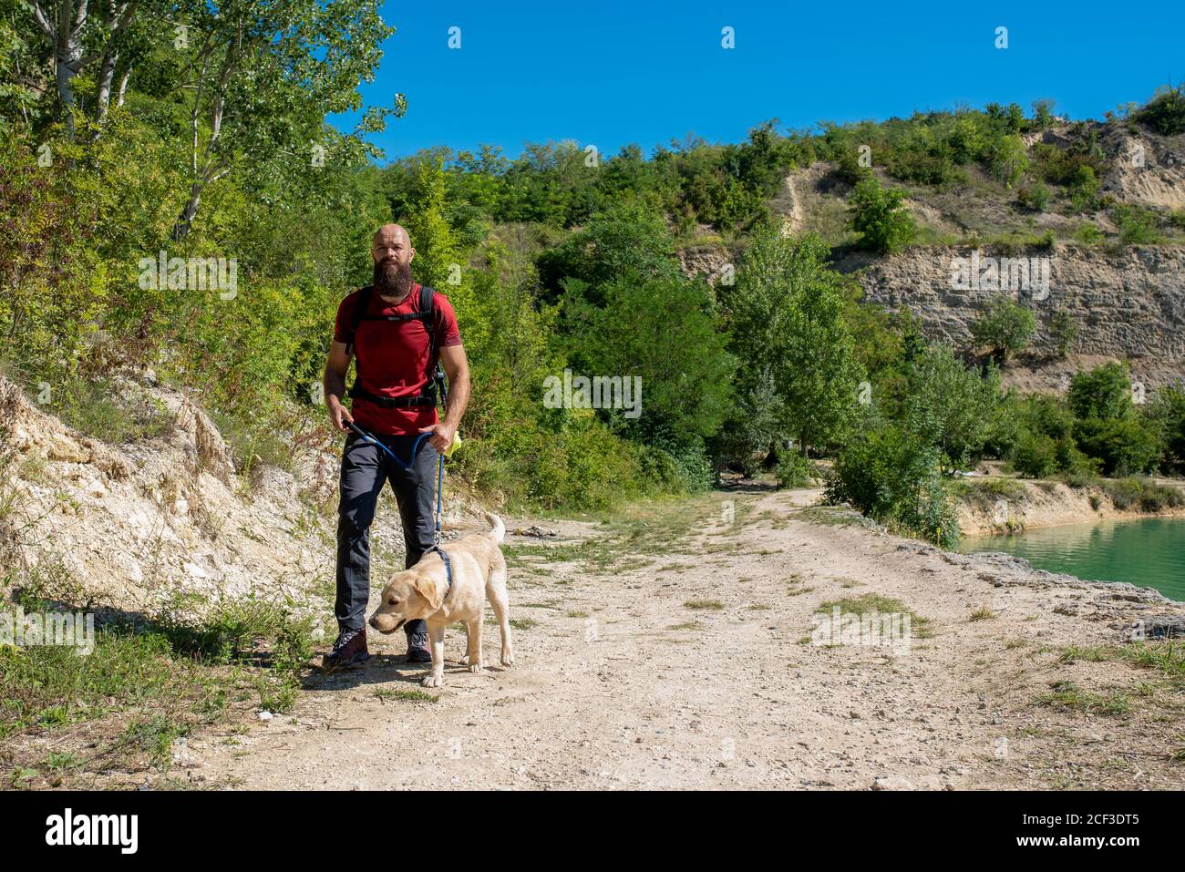 Young Caucasian male tourist exploring beautiful places with his dog ...