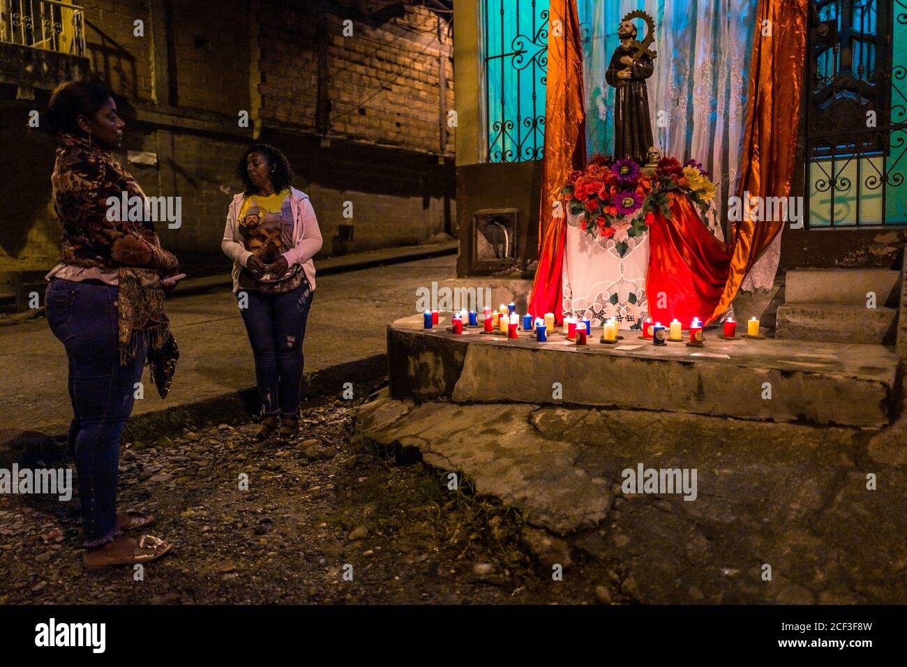Afro-Colombian Catholic followers pray in front of a street altar ...