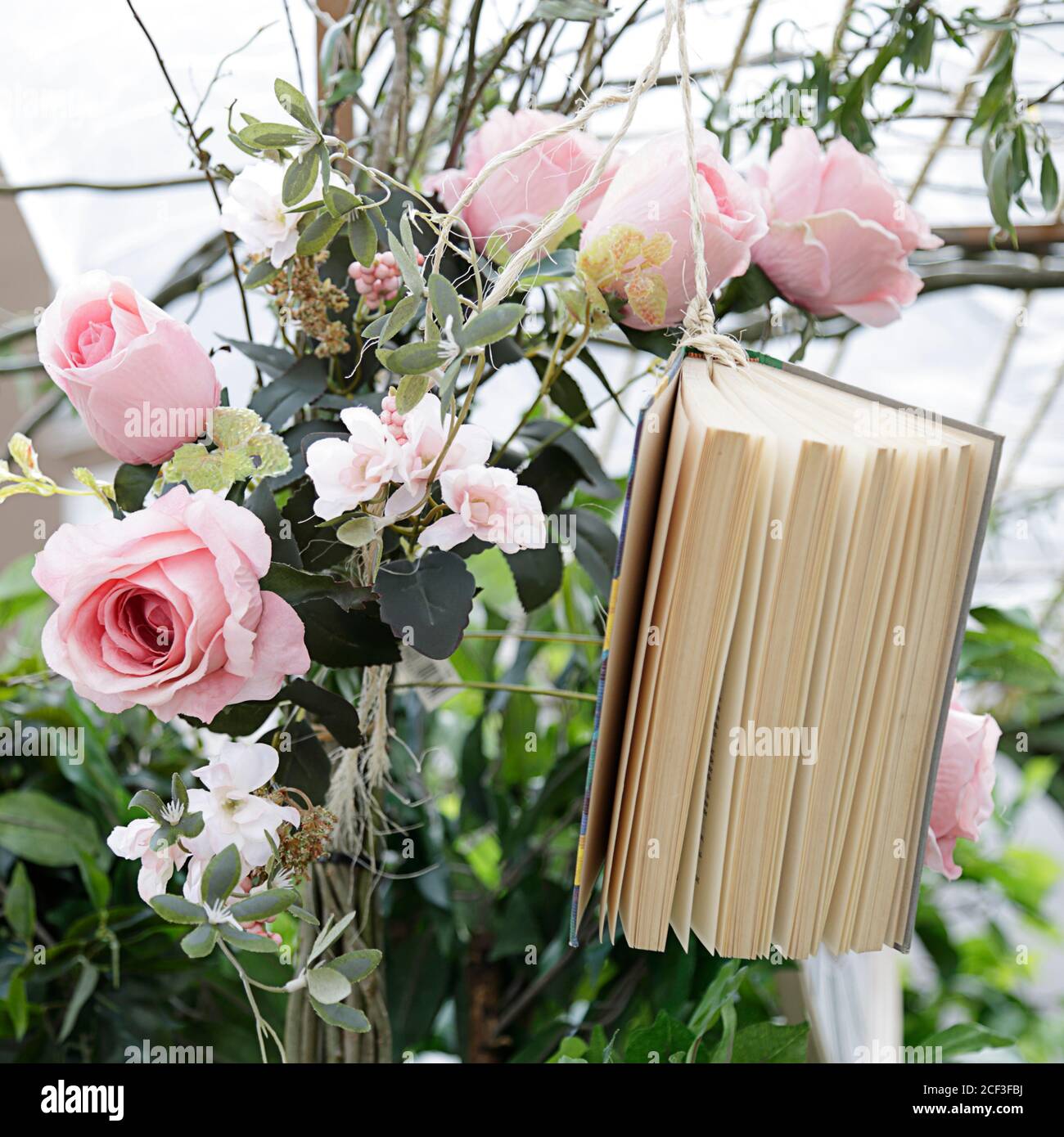 Floral ornament with pink roses and a book hanging on a rope Stock ...