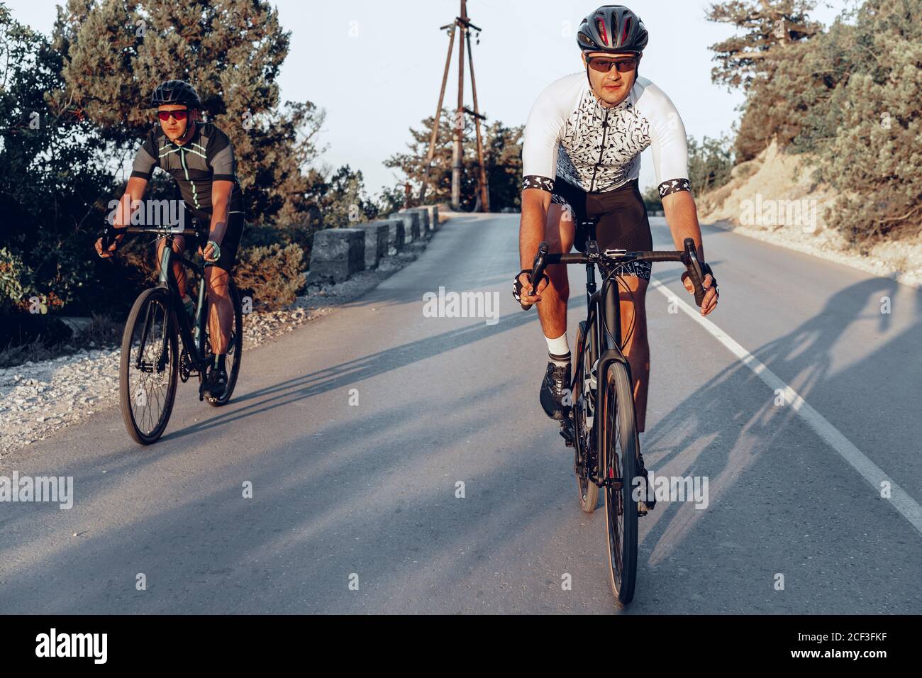 Two professional male cyclists riding their racing bicycles in the ...