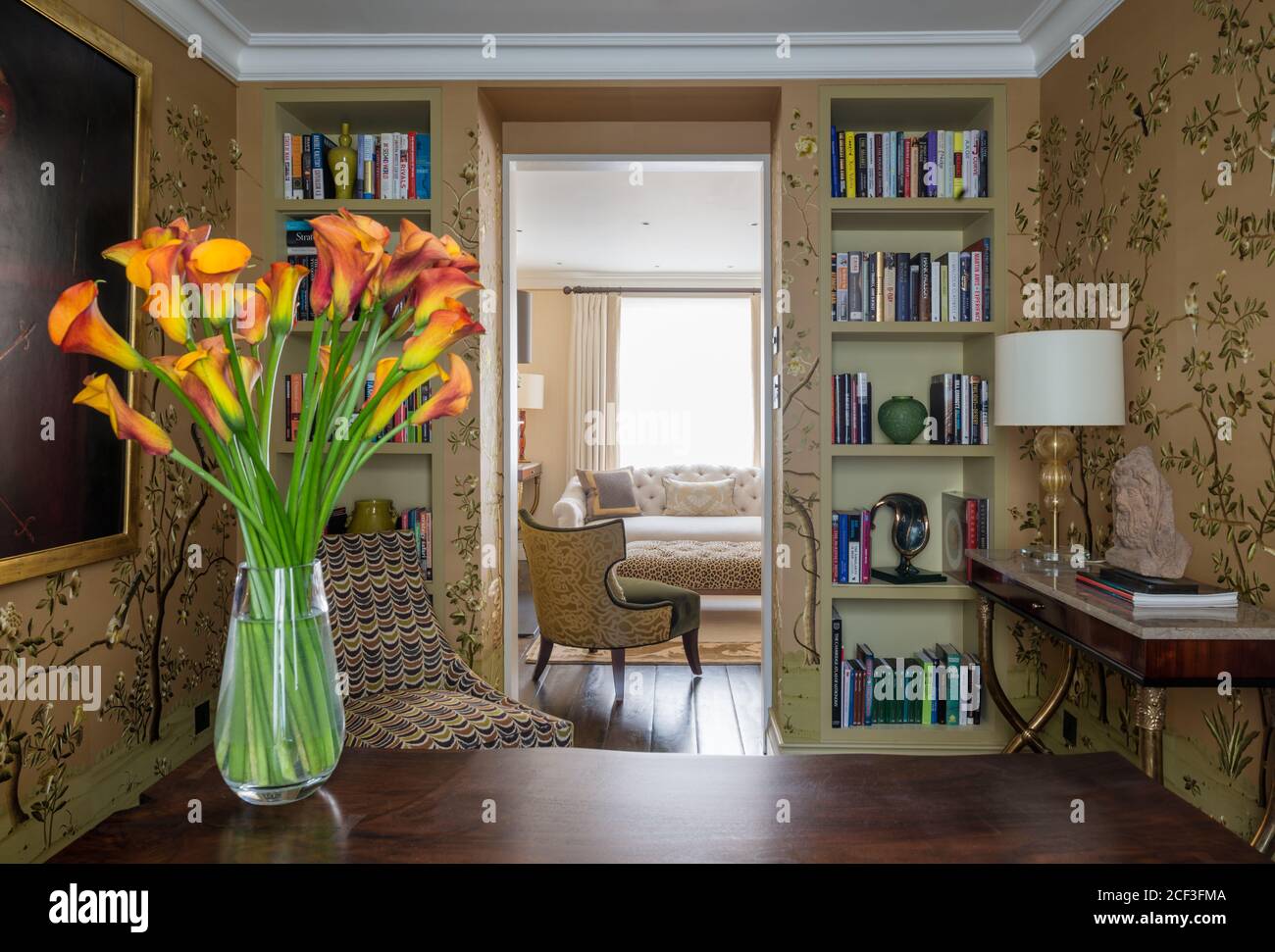 Flower arrangement by recessed bookcases Stock Photo - Alamy