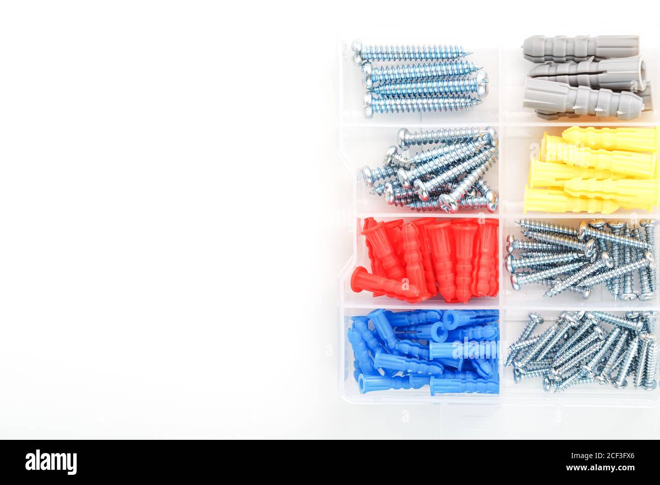 Screws and dowels of various sizes, types and colors in a transparent ...