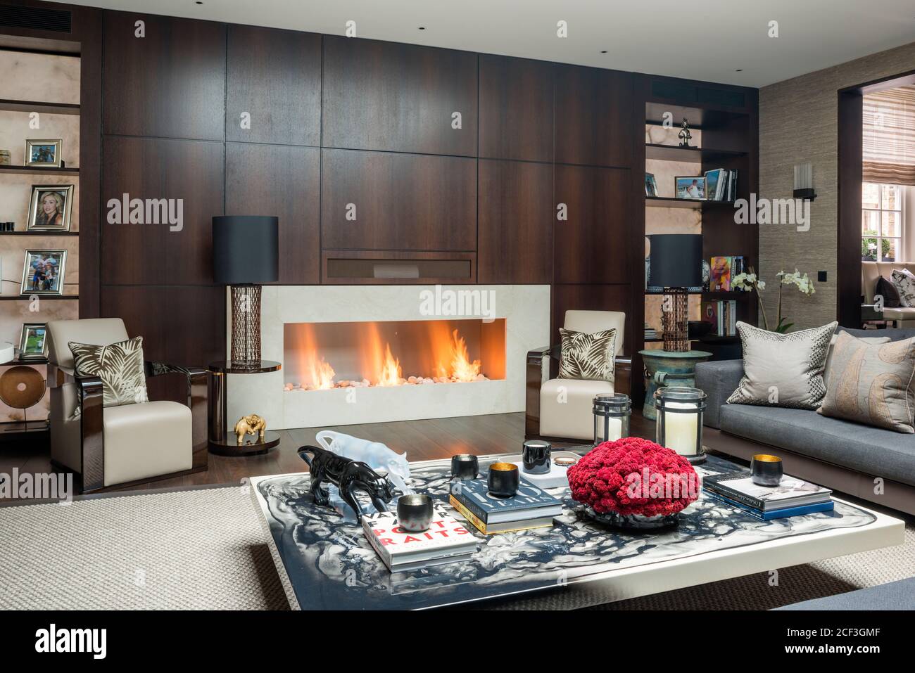 Lit fire in modern living room Stock Photo - Alamy