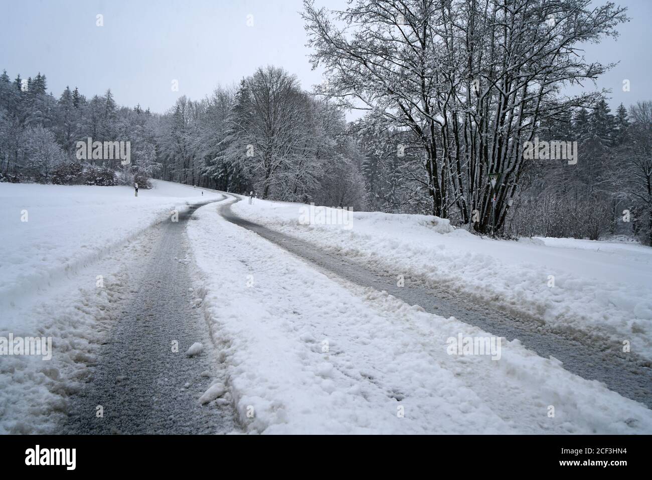 View of a road partially covered with snow Stock Photo - Alamy