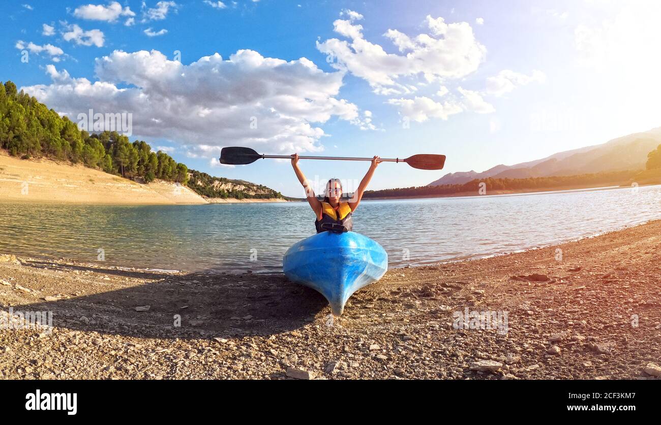 Woman on kayak holding oar rowing at seascape against sunset. Success ...