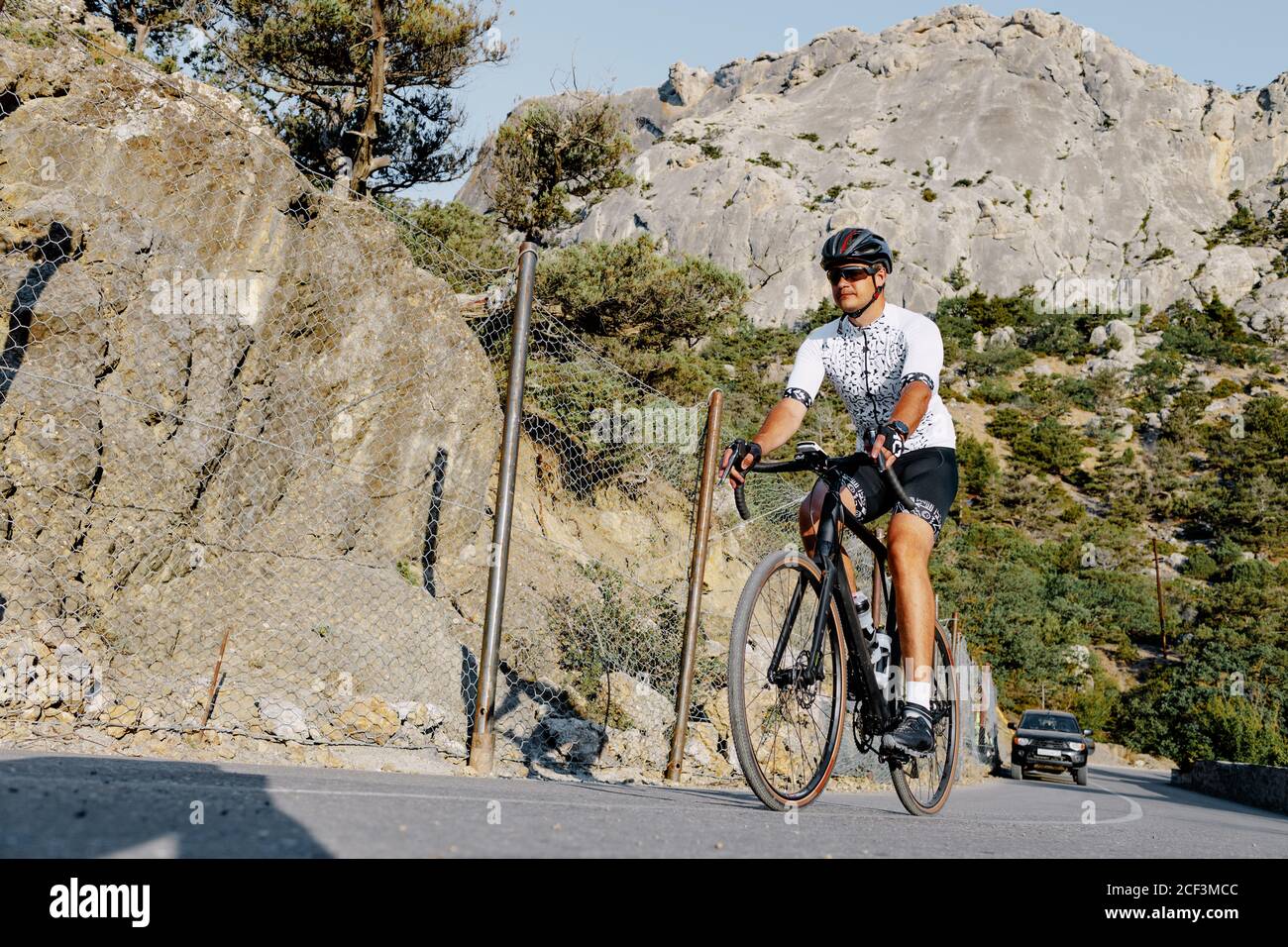 Professional road bicycle racer in action on mountain road Stock Photo ...