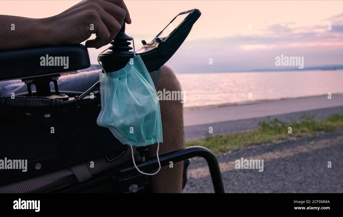 Face mask on wheelchair near sea at sunset Stock Photo - Alamy