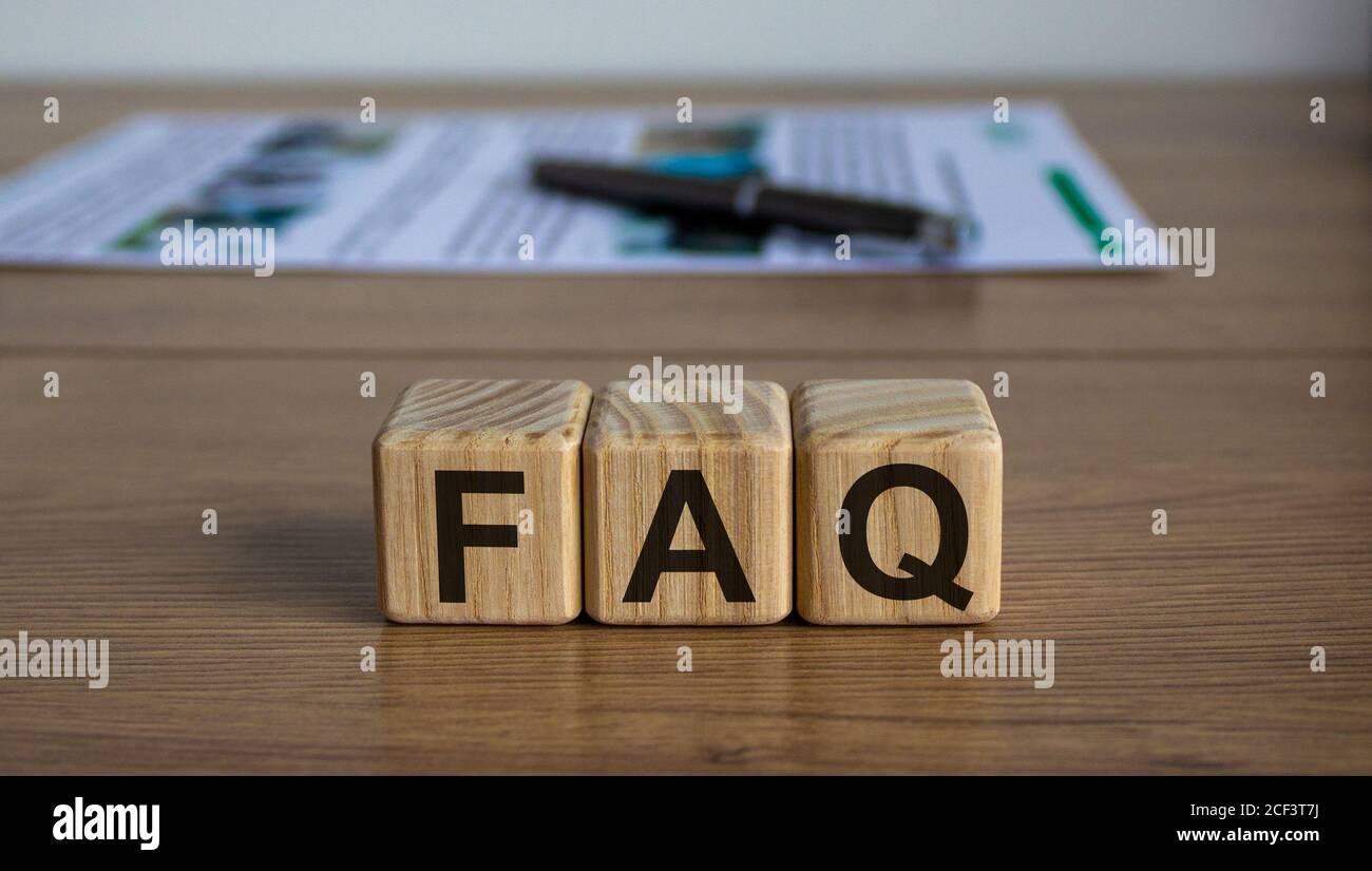 Word 'FAQ' on cubes on a beautiful wooden table, pen and documents ...