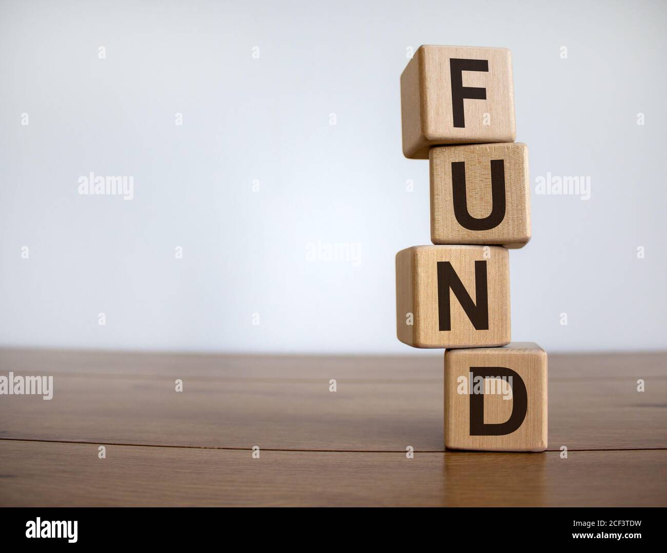 Concept word 'fund' on cubes on a beautiful wooden table. White ...