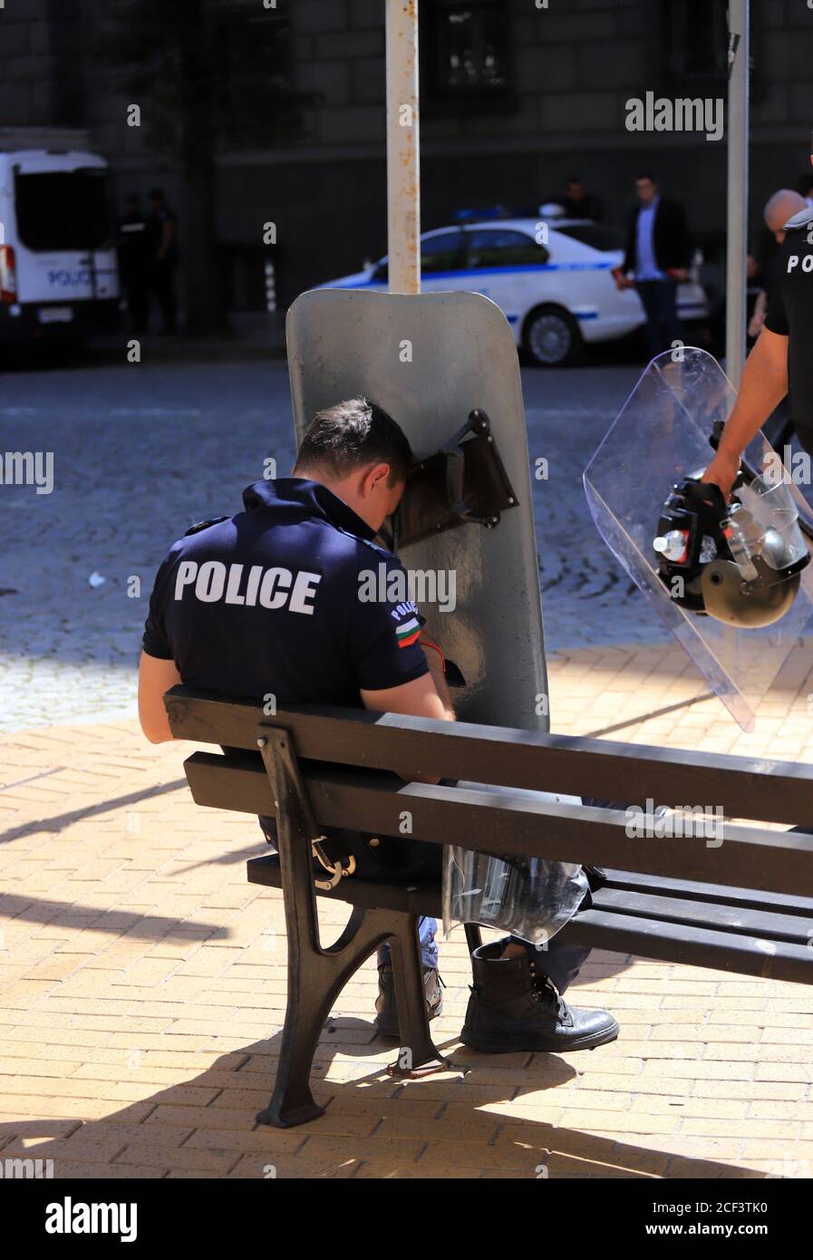 Unrecognizable police officer sleeps on a bench over his shield Stock ...