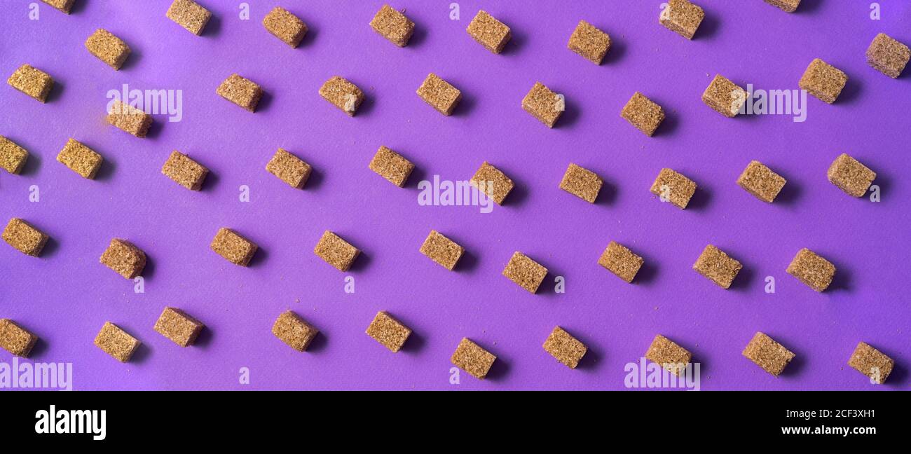 Pattern of brown sugar on a purple background. Minimalism style, banner ...