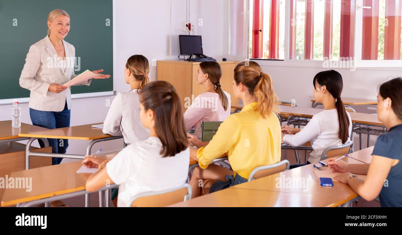 Female speaker giving lesson for university students in lecture hall ...