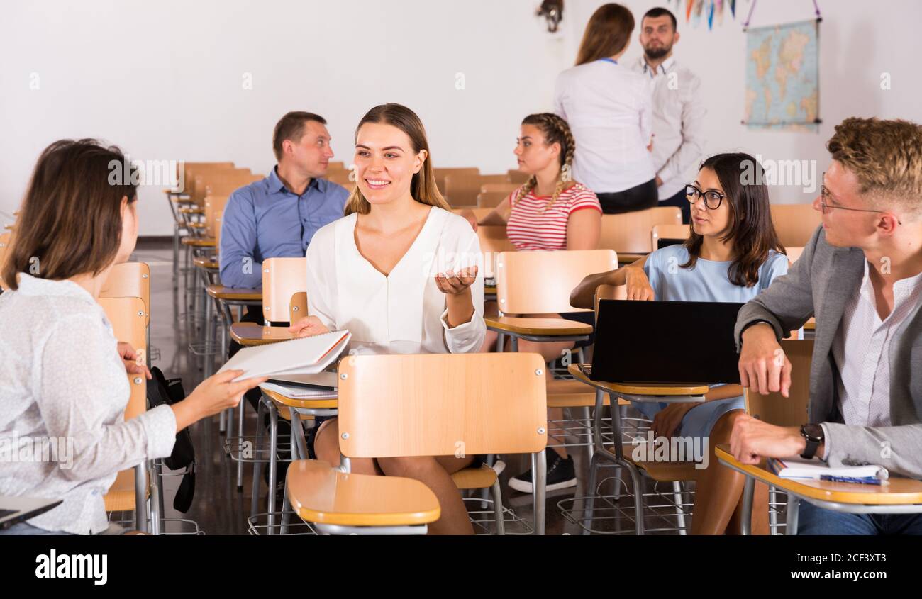Smiling adult students communicating during recess between lectures in ...