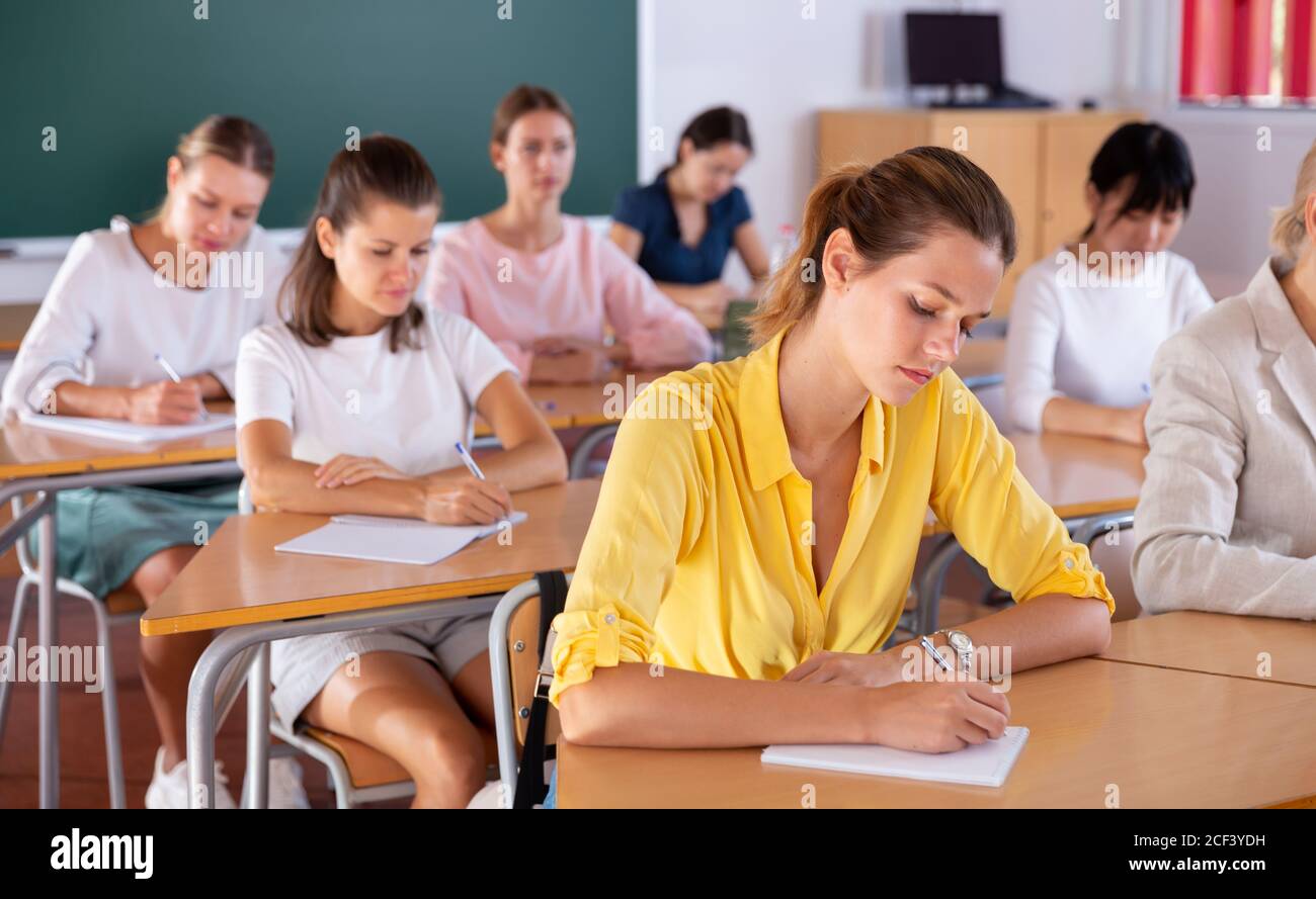 Group of focused female students writing notes in auditorium Stock ...