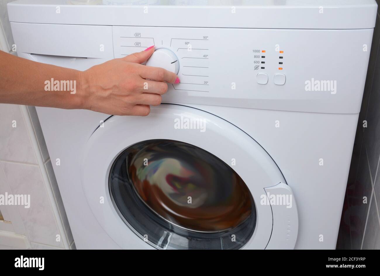View on how a woman is turning on of the washing machine Stock Photo ...
