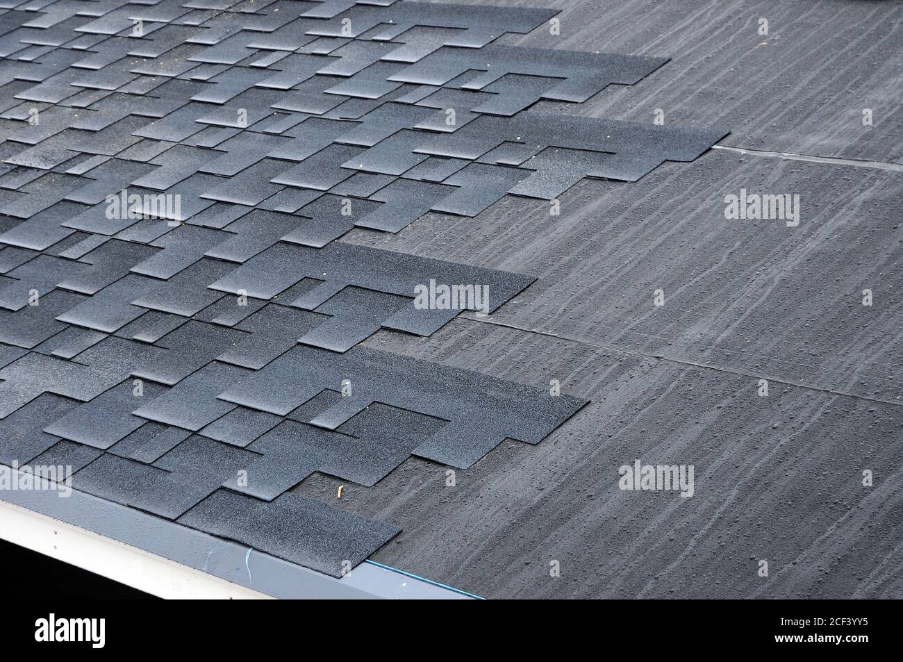 Installing bitumen roof shingles Stock Photo - Alamy