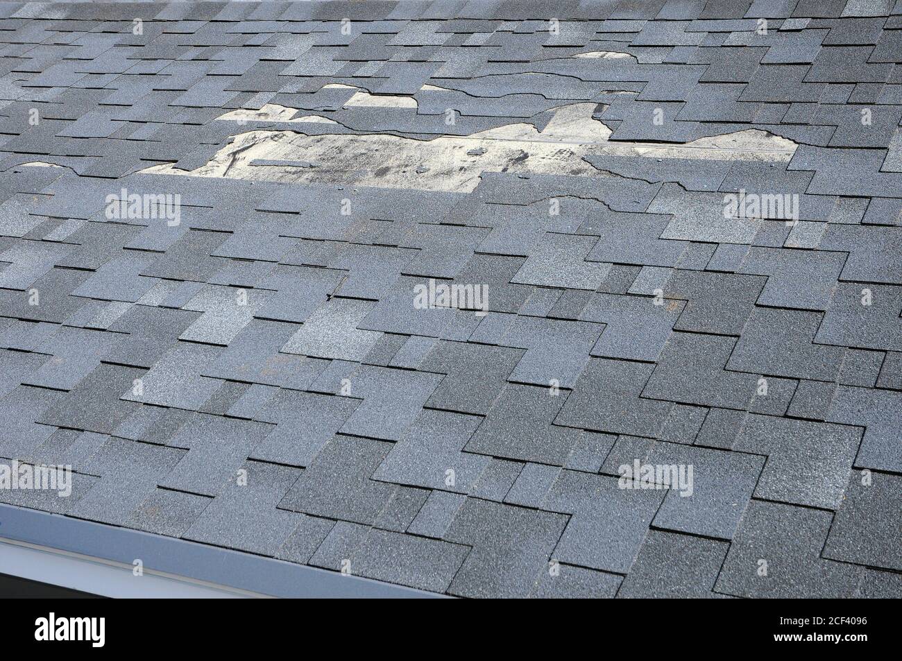A close up view of shingles a roof damage Stock Photo - Alamy