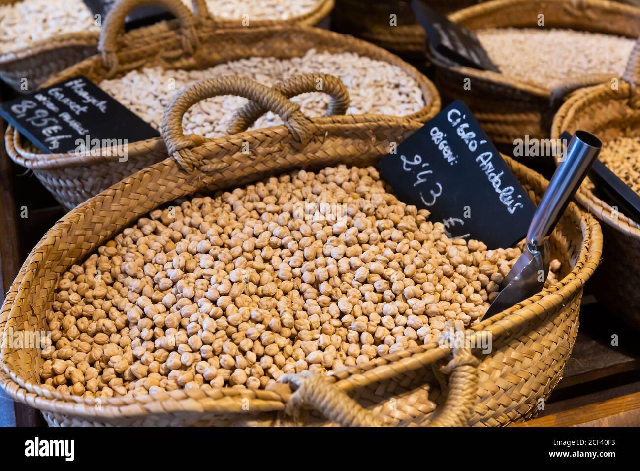 Dried yellowish garbanzos in wicker basket on market counter. Organic ...