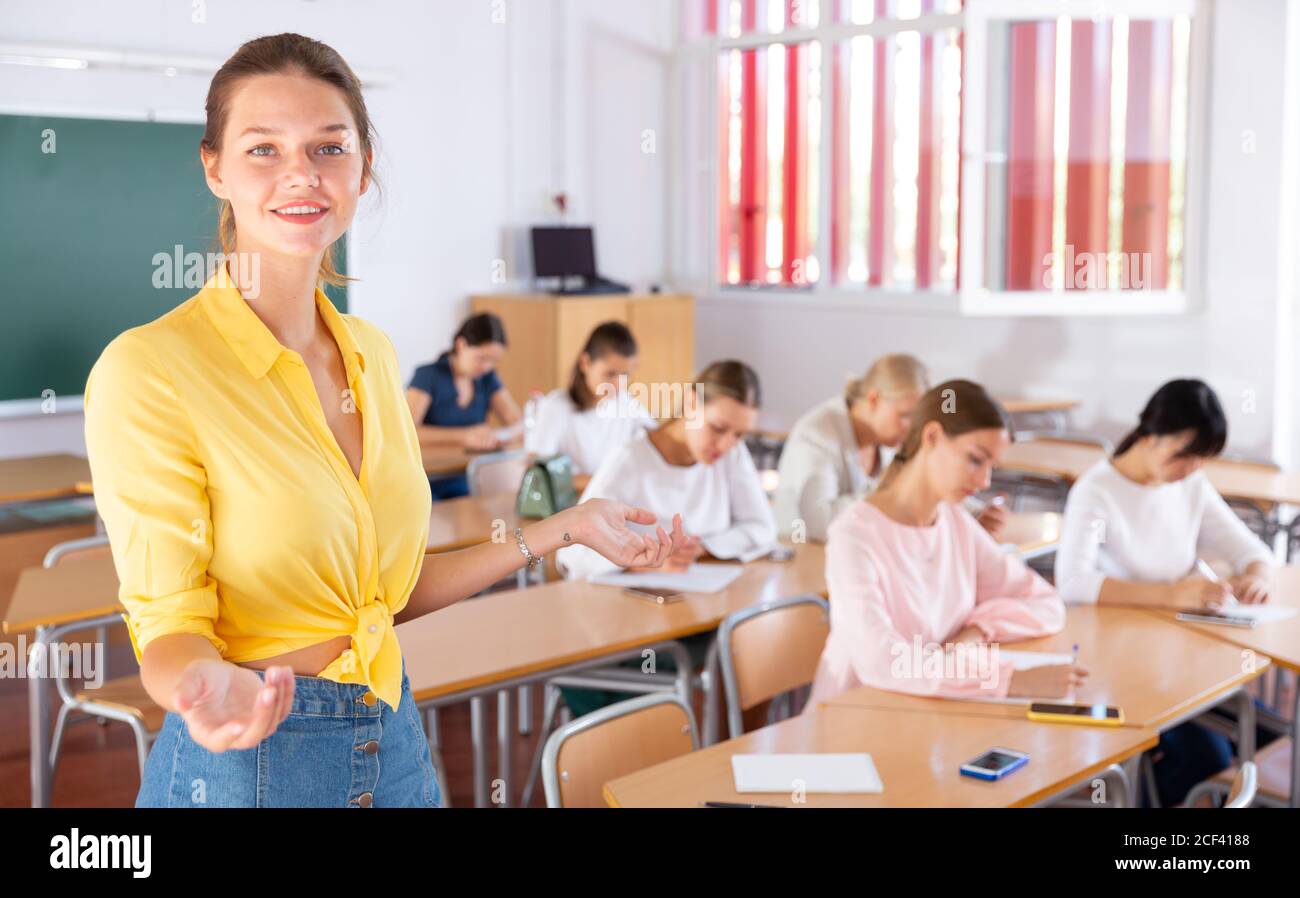Portrait of positive young woman student standing in lecture hall Stock ...