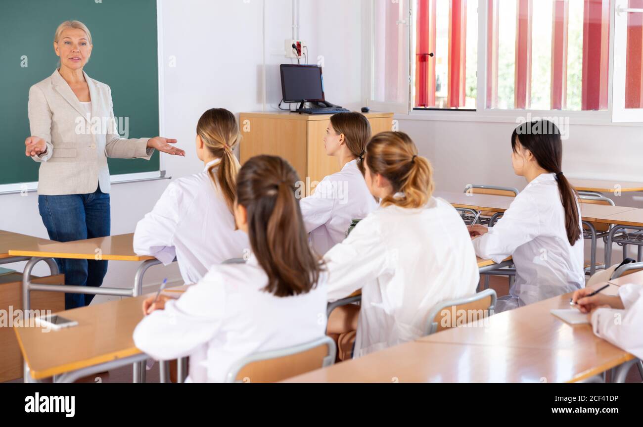 Female professor giving lesson for medical students in lecture hall ...