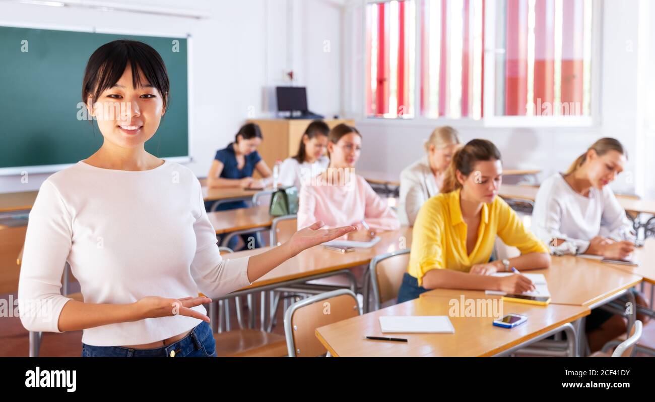 Positive young asian female student standing in classroom, students ...