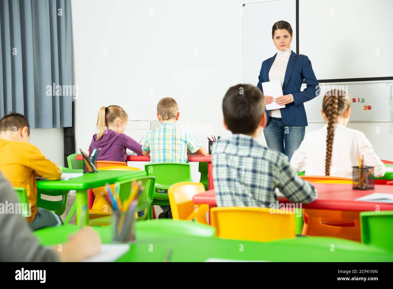 Little children working with teacher in classroom Stock Photo - Alamy