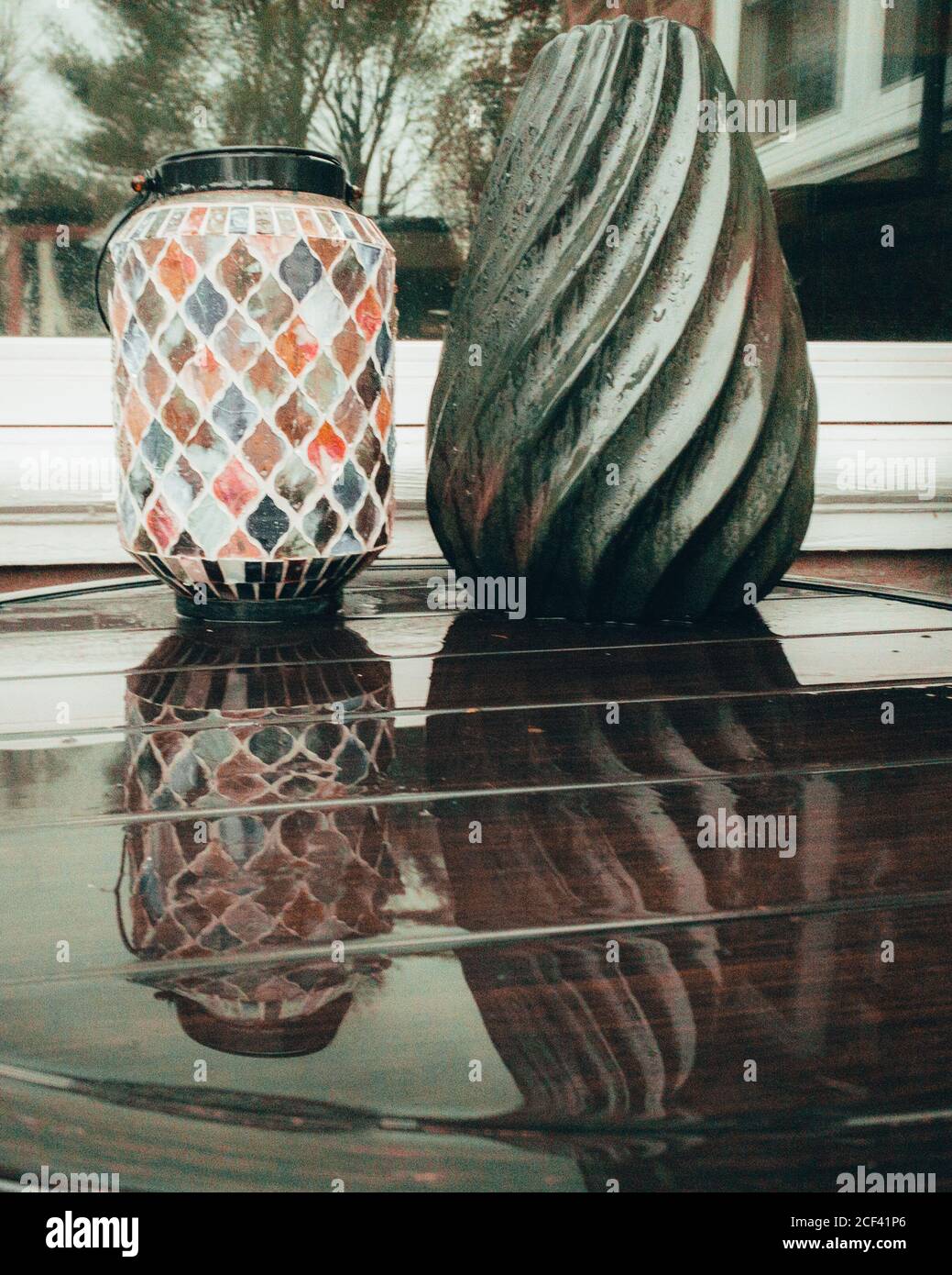 Two Detailed Vases on a Wet Brown Table Casting a Reflection on It ...