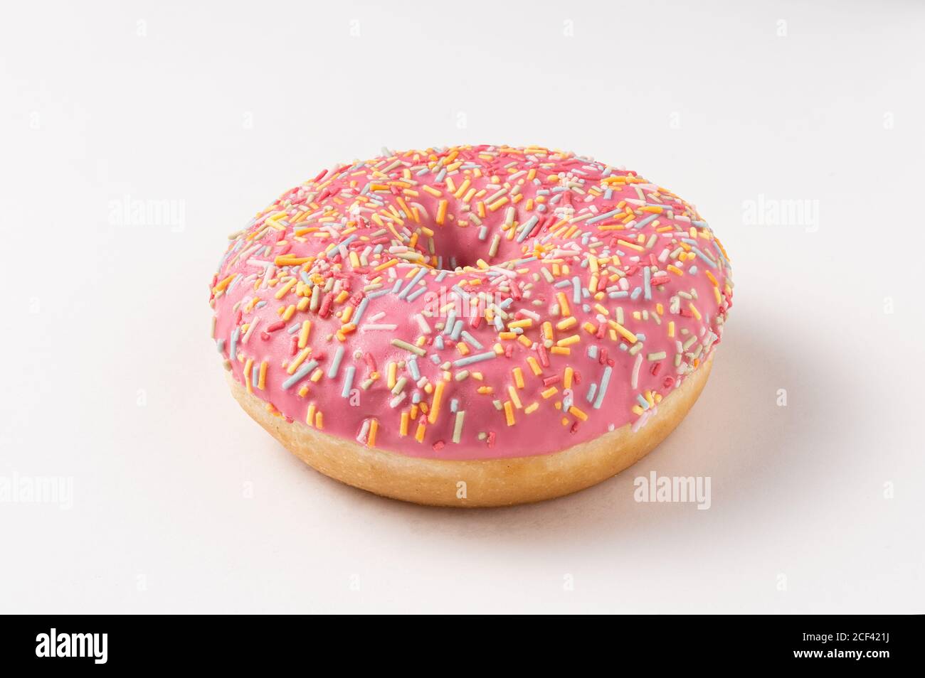 Whole tasty sweet sprinkled pink glazed donuts on white background ...