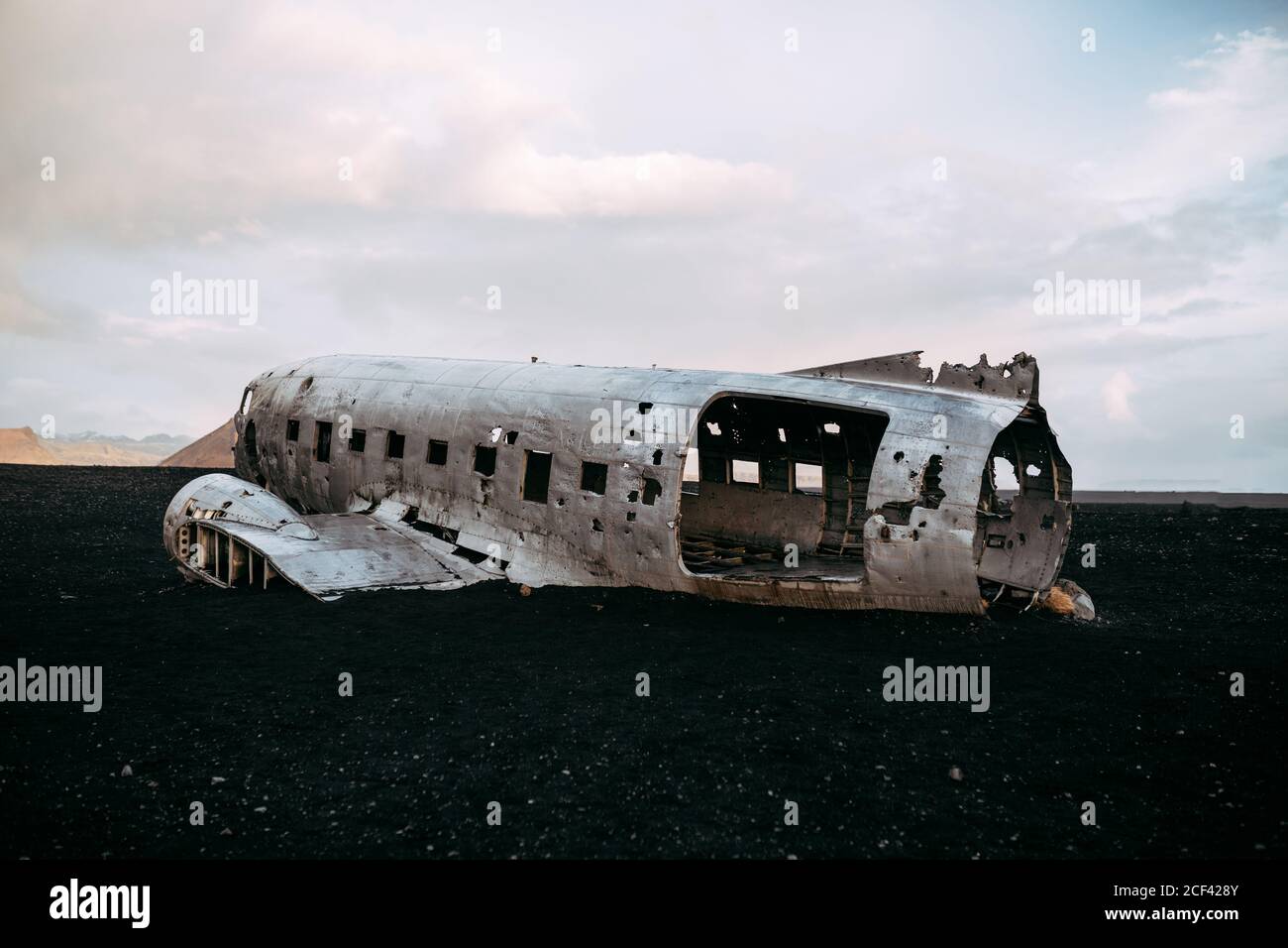 Carcass of crashed plane located on black ground of desolated field on ...