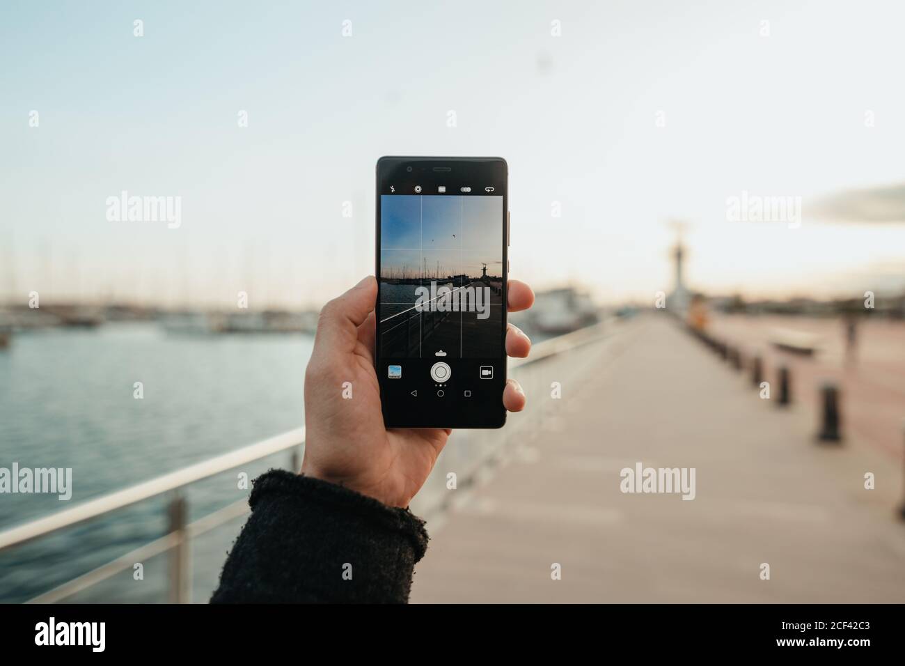 Hand of anonymous man using smartphone to take photo of empty ...