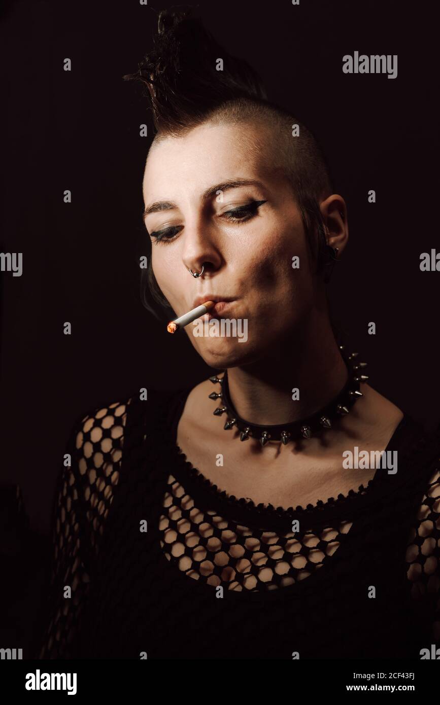 Adult female with mohawk and piercing smoking cigarette Stock Photo - Alamy