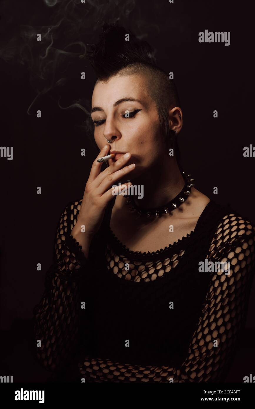 Adult female with mohawk and piercing smoking cigarette Stock Photo - Alamy