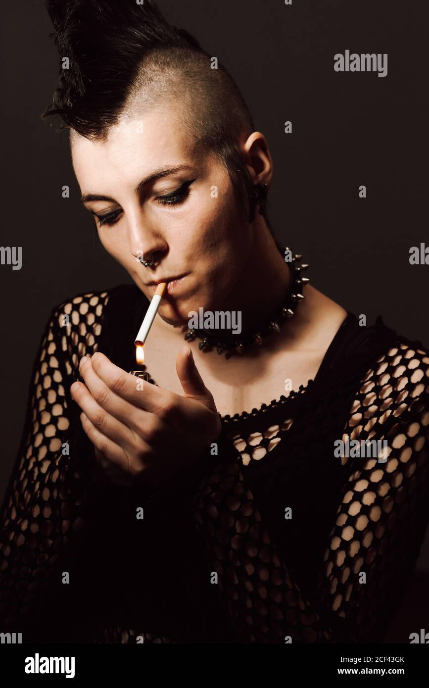 Adult female with mohawk and piercing smoking cigarette Stock Photo - Alamy