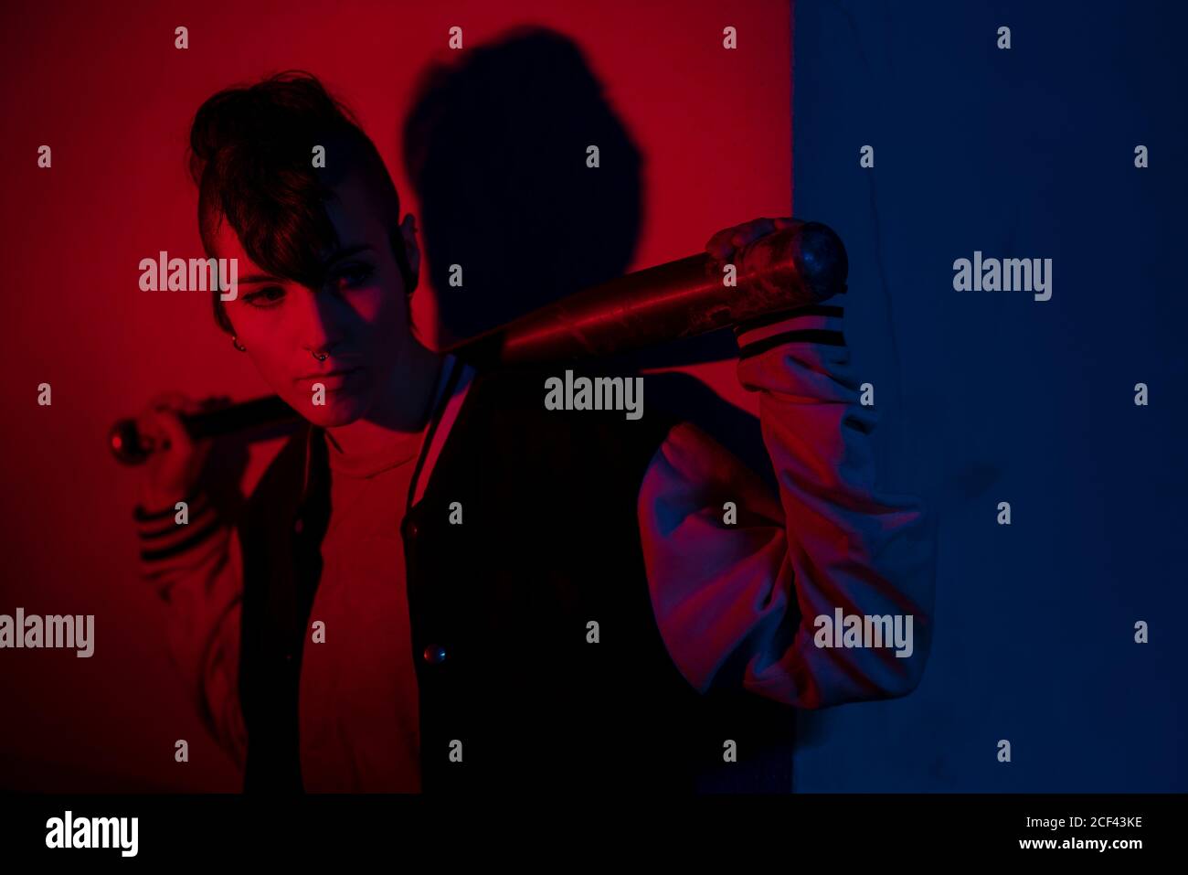 Unconventional Woman with modern hairstyle standing against wall with ...