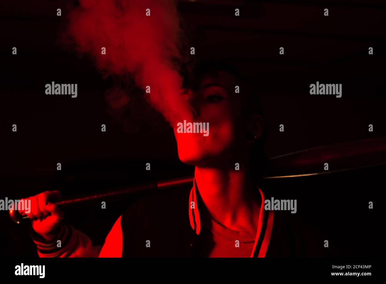 Contemporary female in bomber jacket holding a black baseball bat on ...