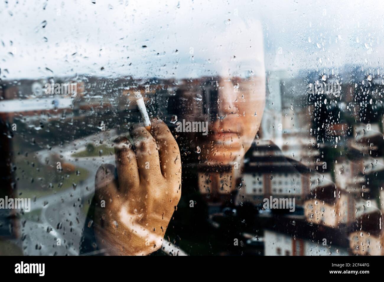man smoking cigarette near window at home Stock Photo - Alamy