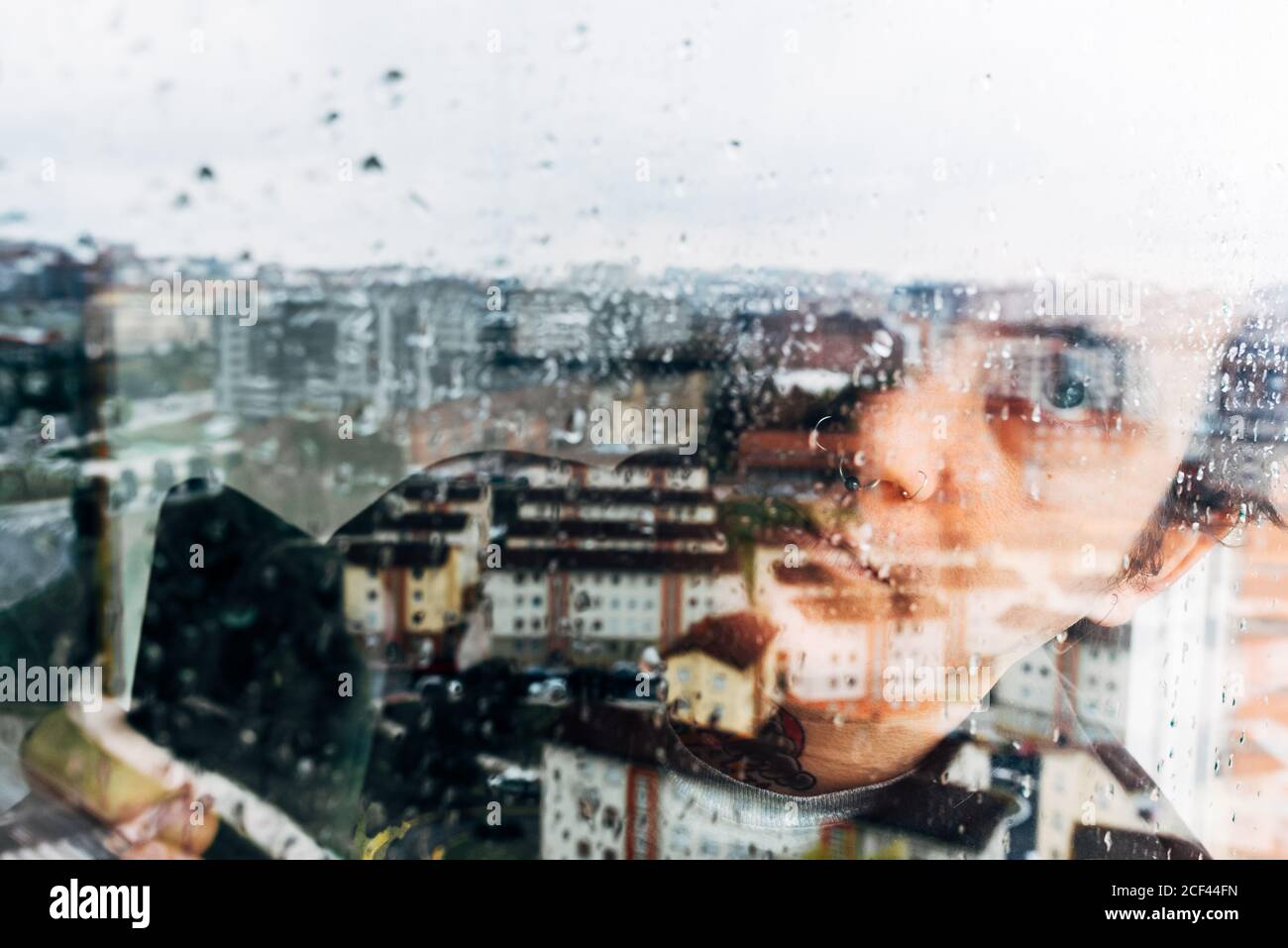 Depressed man looking through window Stock Photo - Alamy