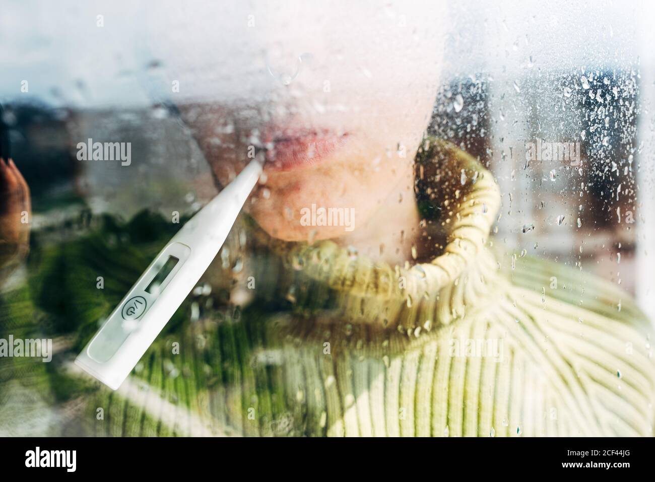 Sick Woman checking body temperature near window at home Stock Photo ...