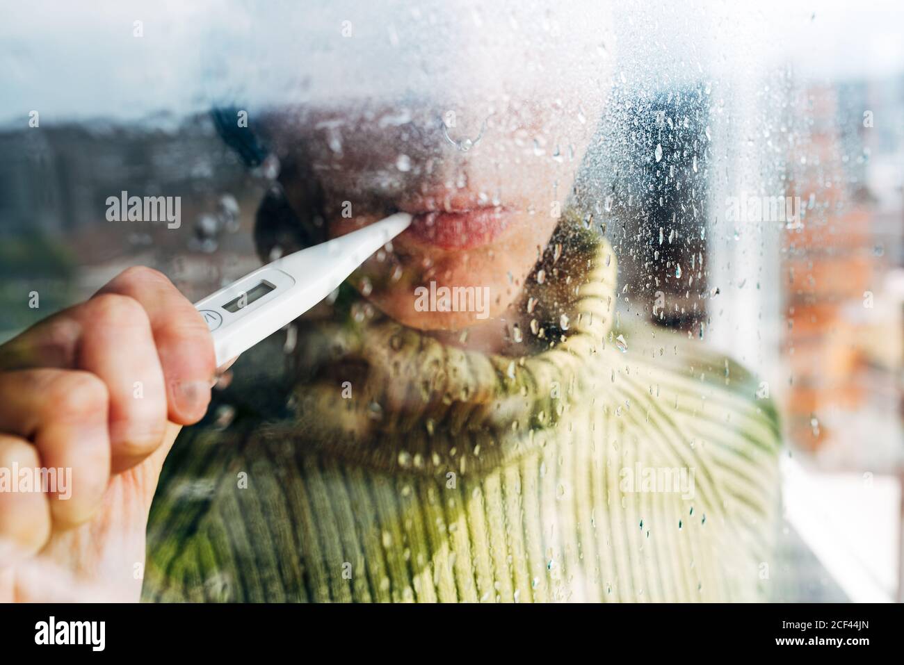 Sick Woman checking body temperature near window at home Stock Photo ...