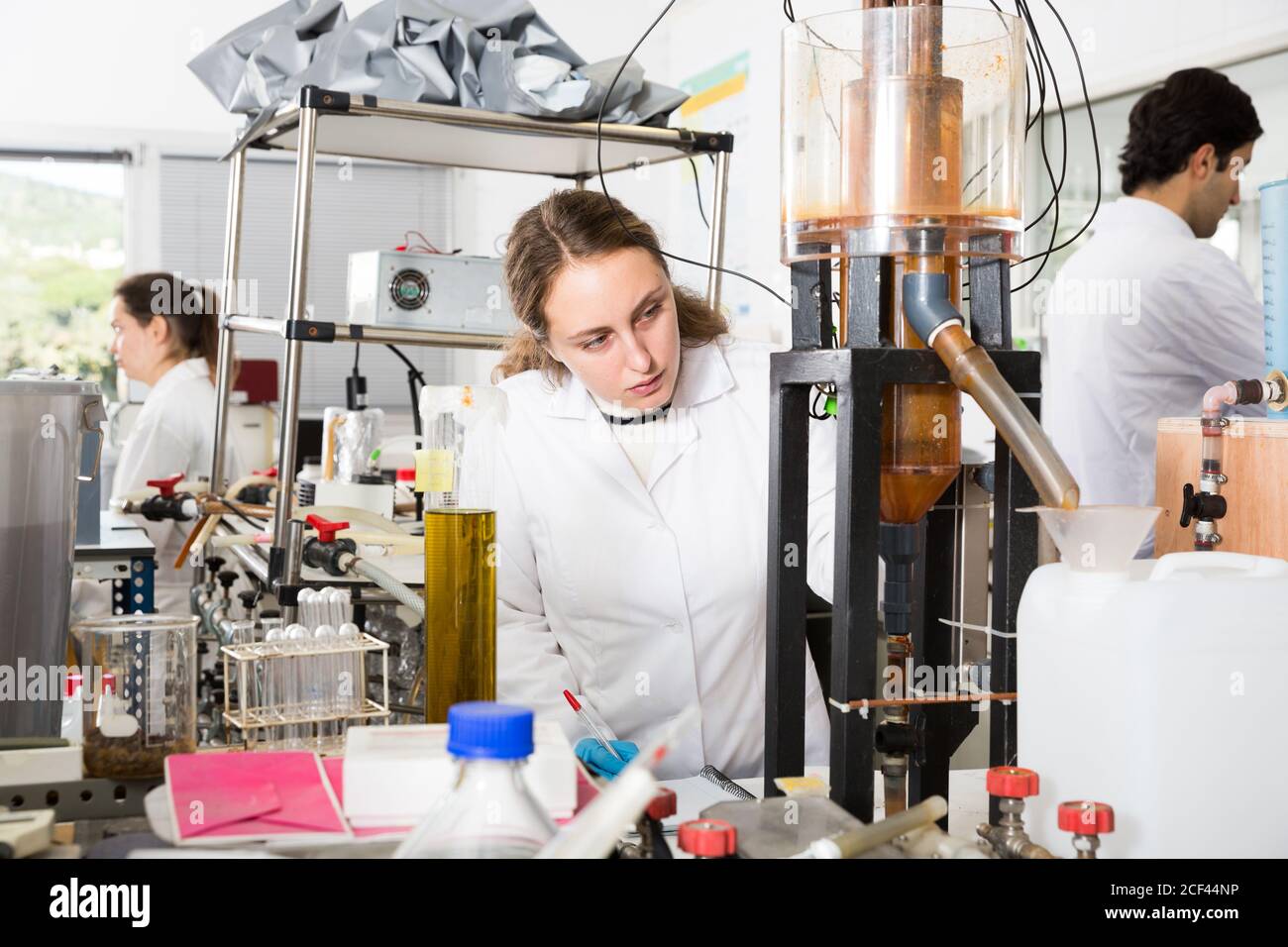 Young female scientist using lab equipment during research in chemical ...