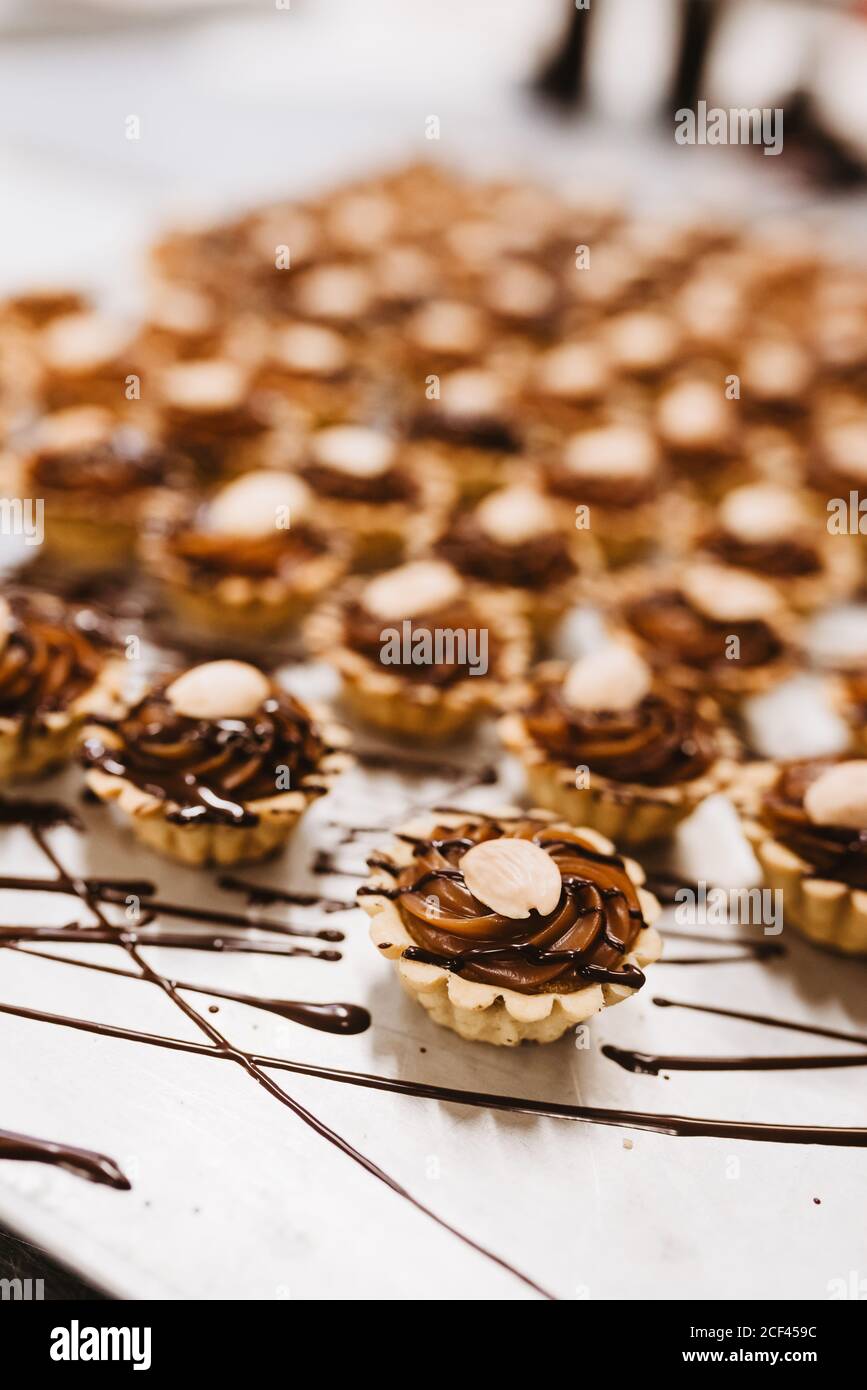Closeup set of yummy pastry with sweet caramel cream and nuts arranged ...