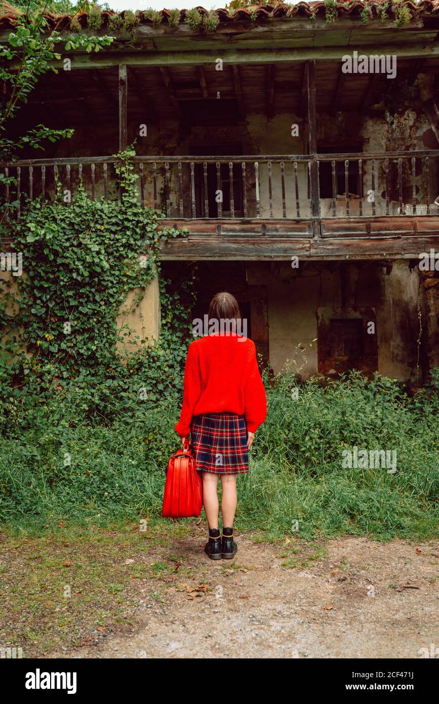 Woman in red with big red suitcase in forest Stock Photo - Alamy